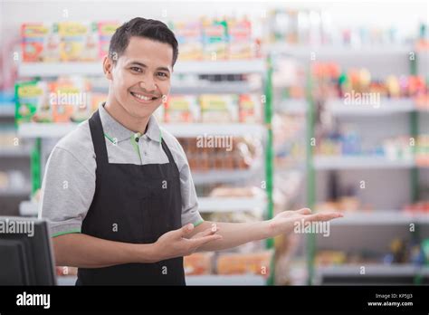 Portrait Of A Smiling Vendeur Dans Un Magasin D Accueillir Le Client