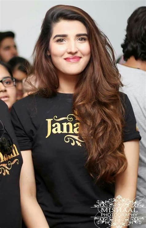 A Woman With Long Hair Standing In Front Of A Group Of People Wearing T