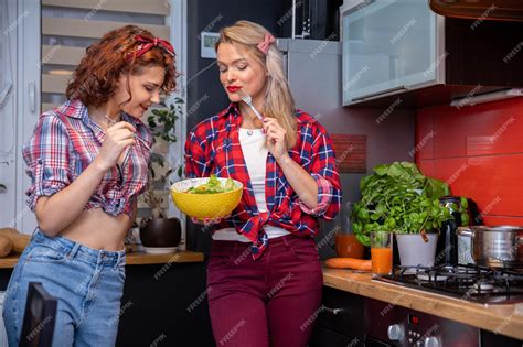 Premium Photo Pinup Girls Eat Salad In Kitchen In One Bowl