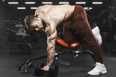 Premium Photo Handsome Strong Athletic Men Pumping Up Muscles Workout