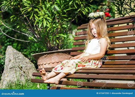 Petite Fille Aux Pieds Nus Mignonne S Asseyant Sur Le Banc Image Stock