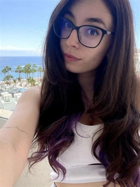 A Woman With Glasses Taking A Selfie In Front Of The Ocean And Palm Trees