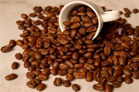 Copo de café derramado feijões roasted Foto Premium