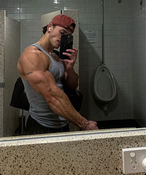A Man Taking A Selfie In Front Of A Bathroom Mirror With His Arm Out
