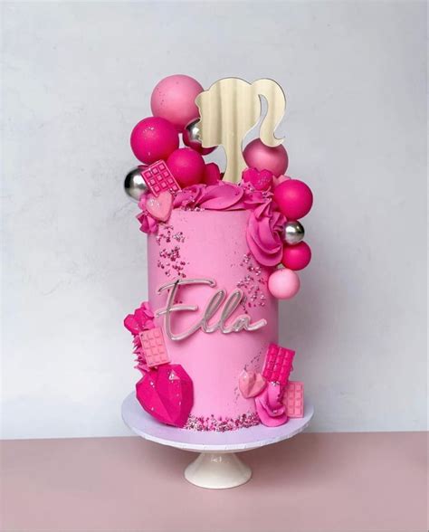 A Pink Birthday Cake With Balloons And Decorations