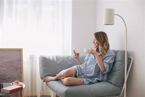 Woman Browsing On Her Mobile Phone Indoor Del Colaborador De Stocksy