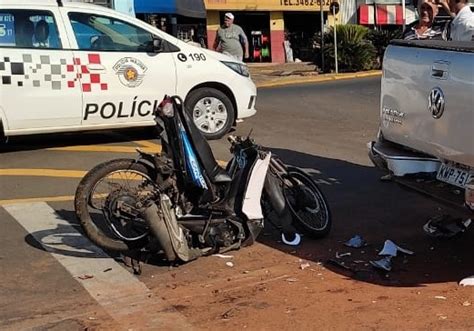 Mulher fica ferida após moto ser prensada entre veículos na rotatória