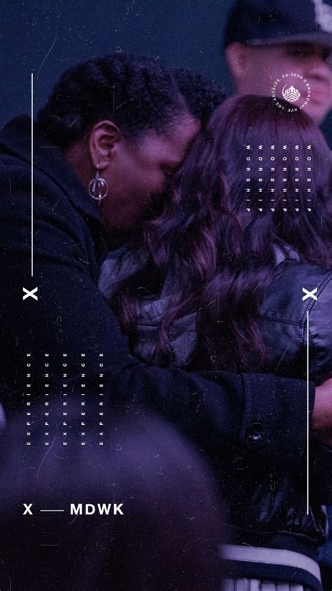 Two People Are Hugging Each Other In Front Of A Screen With The Words M