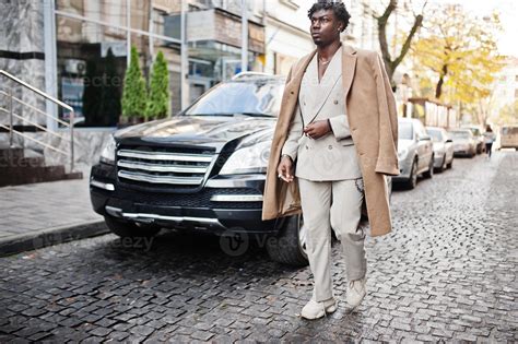 Stylish Afro Man In Beige Old School Suit And Coat Walking Against