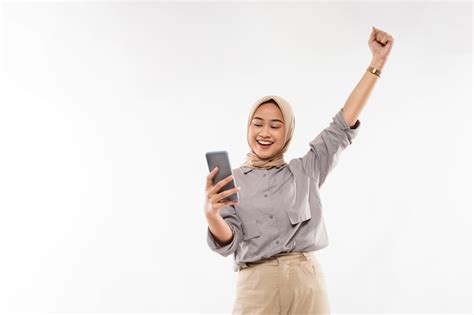 Una mujer con hiyab sonriendo mientras está de pie con el brazo
