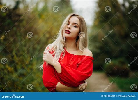 Gorgeous Blonde Woman In Red Blouse Posing With Naked Shoulder A Stock
