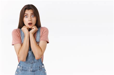 Conmocionada asustada tímida insegura linda chica con peto y camiseta