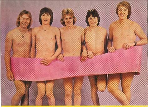 A Group Of Naked Men Standing Next To Each Other Holding A Pink