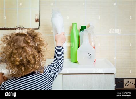 Petit enfant tend la main aux produits chimiques ménagers Garder hors