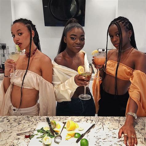 Three Beautiful Women Standing Next To Each Other Holding Drinks