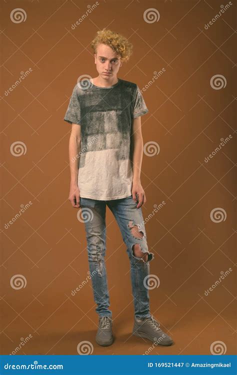 Joven Flaco Con El Pelo Rizado Y Fondo Marrón Imagen de archivo