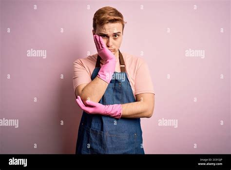 Young Handsome Redhead Cleaner Man Doing Housework Wearing Apron And Gloves Thinking Looking