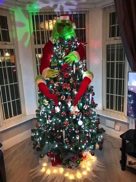 The Grinch Is Sitting On Top Of The Christmas Tree