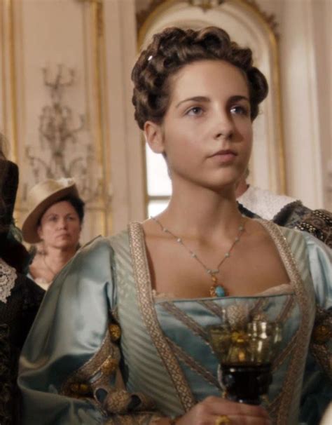 Two Women In Period Dress Standing Next To Each Other One Holding A
