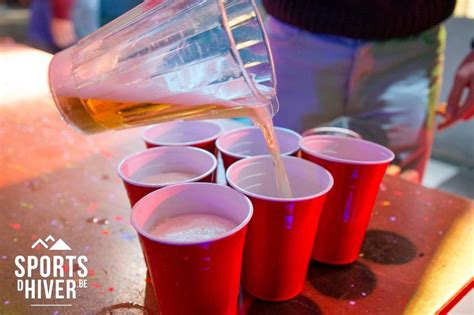 A Person Pouring Some Drinks Into Red Cups