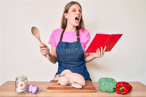 Jovem Loira Usando Avental Profissional Lendo Livro De Receitas