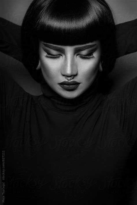 A Black And White Photo Of A Woman With Dark Makeup