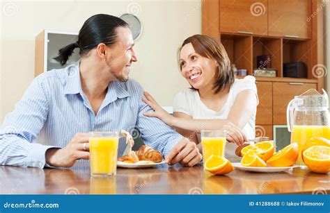Pares Felices Que Desayunan Con Los Huevos Revueltos Y Las Naranjas