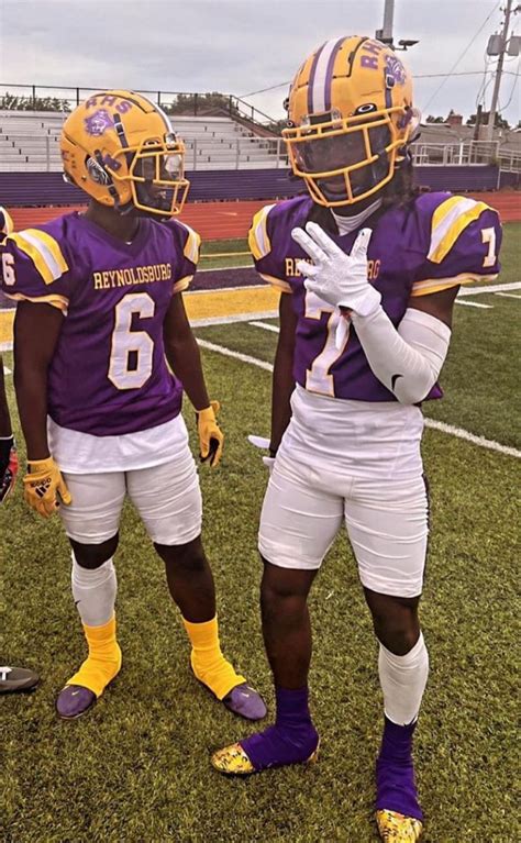 Two Football Players Are Standing On The Field