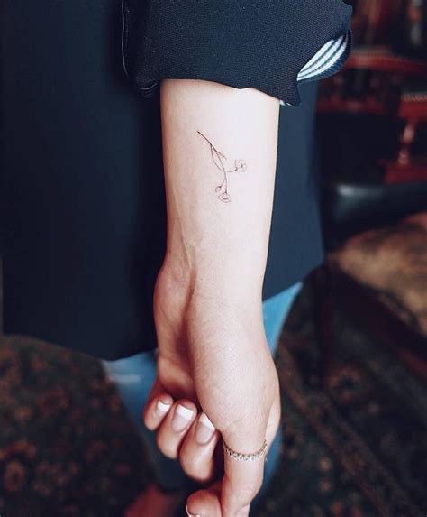 Fine line style flower tattoo on the left wrist Gänseblümchen tattoo