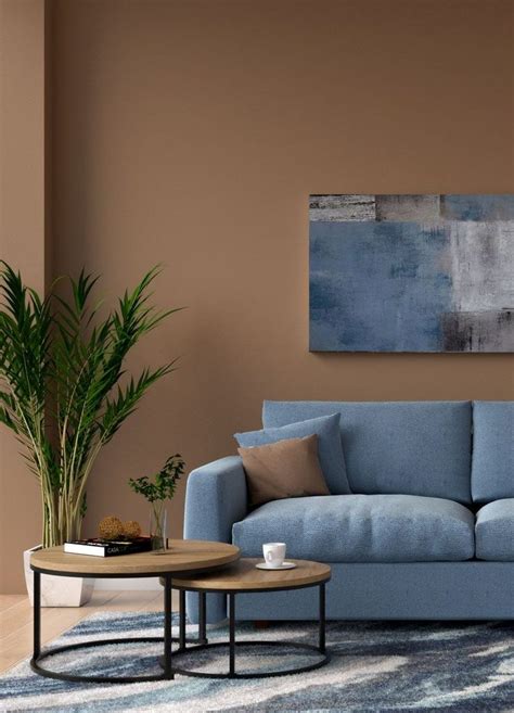 A Living Room With A Blue Couch And Coffee Table In Front Of A Painting