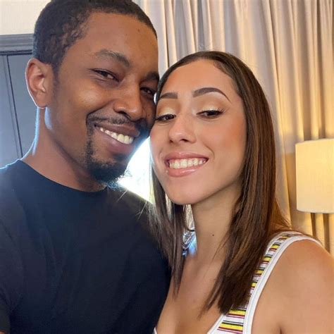 A Man And Woman Are Smiling For The Camera