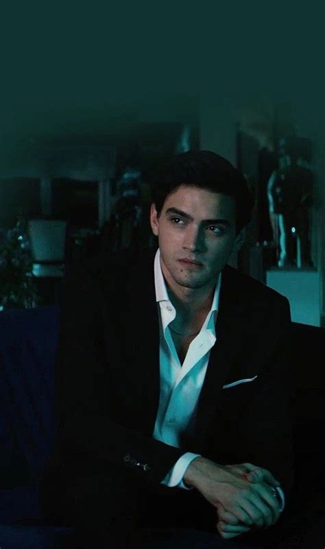 A Man In A Suit Sitting On A Couch