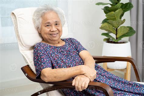 Asian Elderly Woman Sitting And Relaxing With Happy In Rocking Chair At