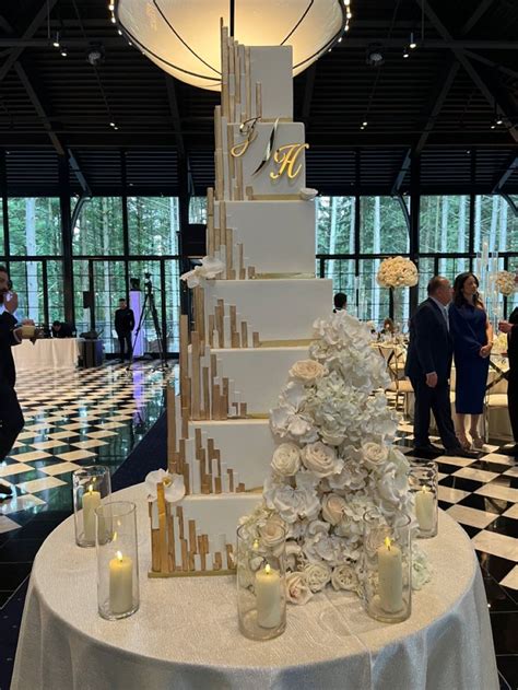 A Tall White Cake Sitting On Top Of A Table