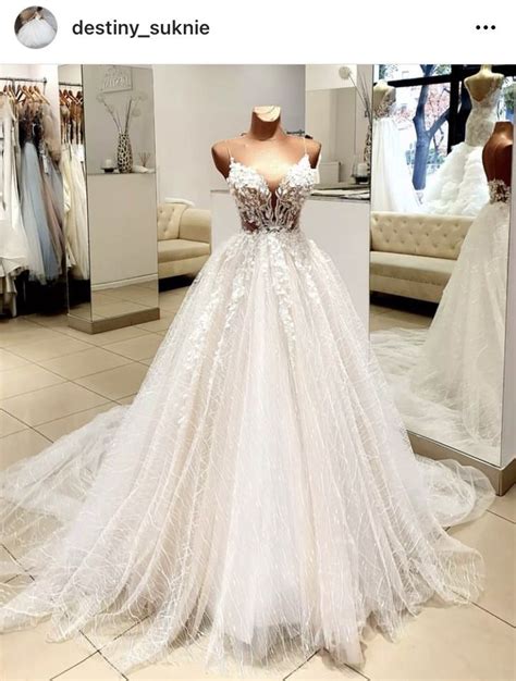 A White Wedding Dress On Display In Front Of A Mirror