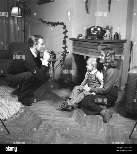 Amateur Photographer In The 1940s A Man Is Taking Pictures Of His Wife And Son At Home He Is