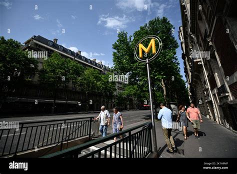 Panneau avec le logo du métro symbole jaune devant une station de