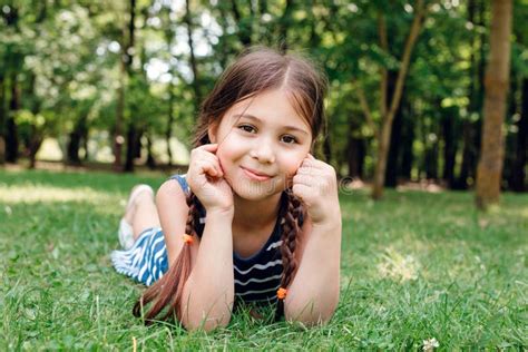 Mignonne Petite Fille Allongée Sur Une Pelouse Verte Et Fraîche En