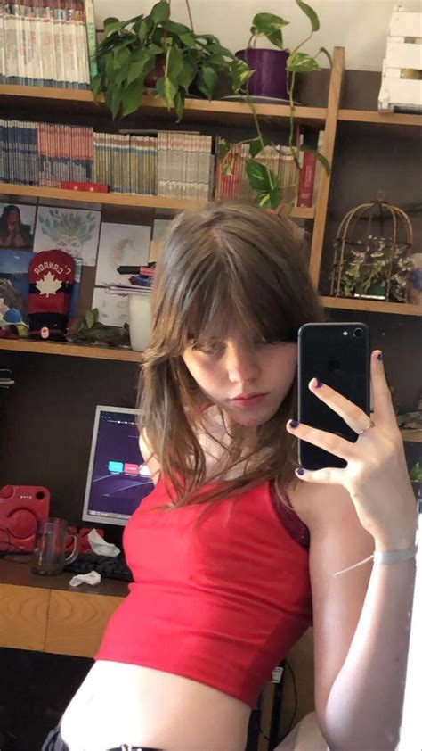 A Woman In Red Shirt Holding Up A Cell Phone