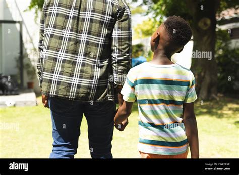 African American Father And Son Hold Hands Viewed From Behind They