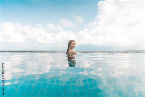 Vacations Of Woman Relax In Tropical Infinity Pool Above The Beach With Beautiful Sea In