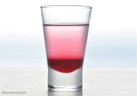 A Glass Filled With Liquid Sitting On Top Of A Table