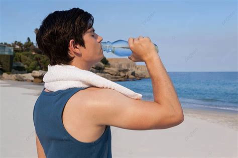 Fondo Hombre Bebiendo Agua De Una Botella En La Playa Foto E Imagen