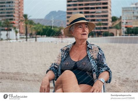 Ältere Frau am Strand mit Strohhut ein lizenzfreies Stock Foto von