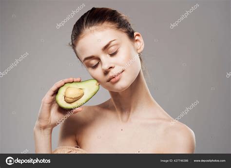 Beautiful Brunette Naked Shoulders Avocado In Clean Skin Hand Stock