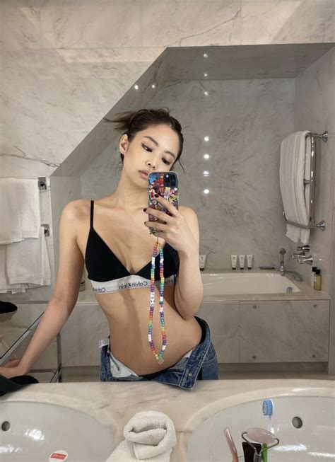 A Woman Taking A Selfie In Front Of A Bathroom Mirror With Her Cell Phone