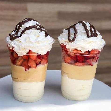 Two Dessert Cups With Strawberries Whipped Cream And Chocolate