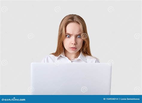 Portrait Of Shocked Woman Sitting In Front Of White Laptop With Wide