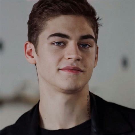 A Close Up Of A Person Wearing A Black Shirt And Looking At The Camera
