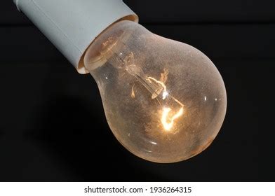 Naked Dusty Light Bulb Glows Electricity Stock Photo 1936264315